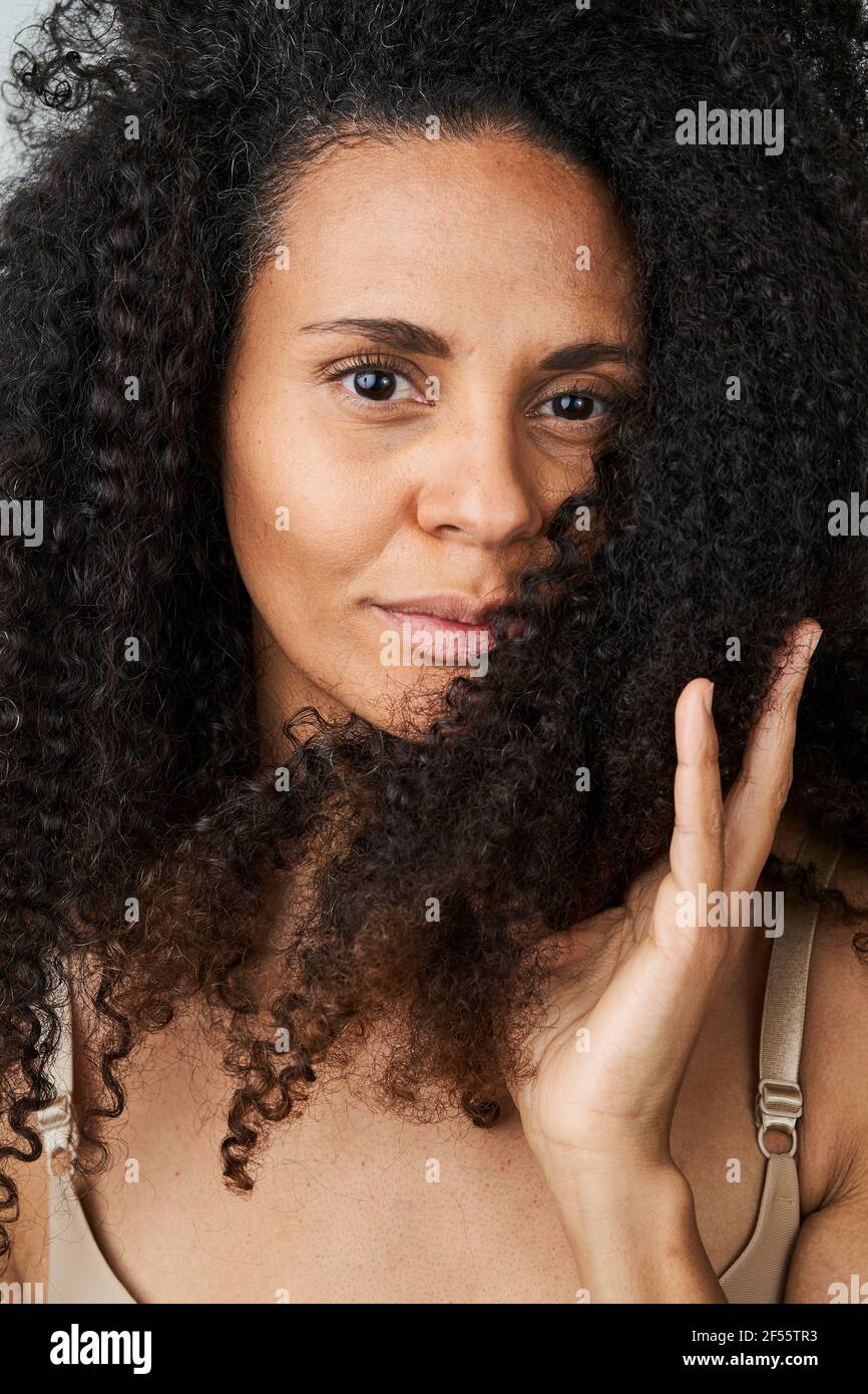 Beautiful woman with hand in curly hair Stock Photo - Alamy