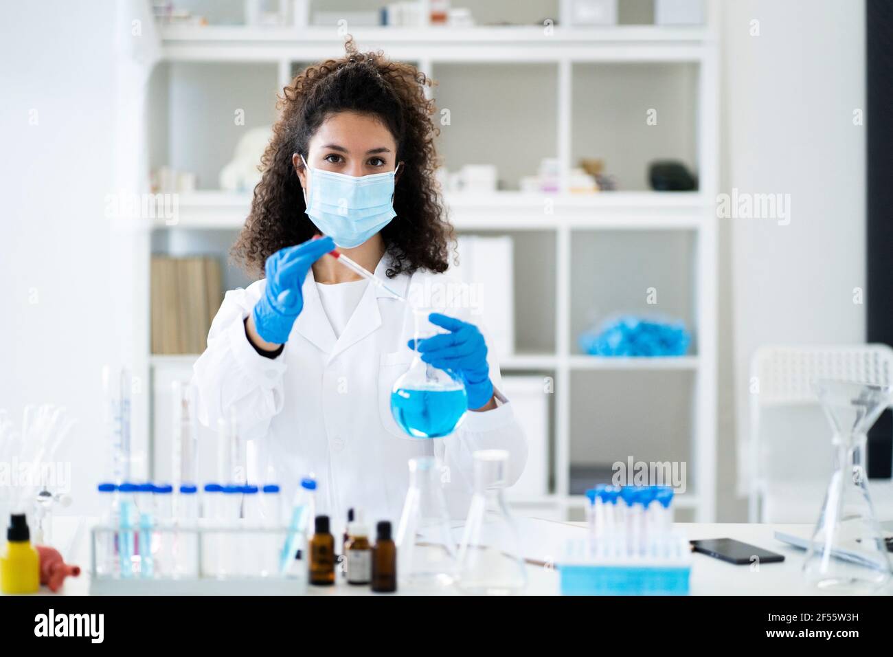 Female doctor testing chemical solution in hospital during COVID-19 ...