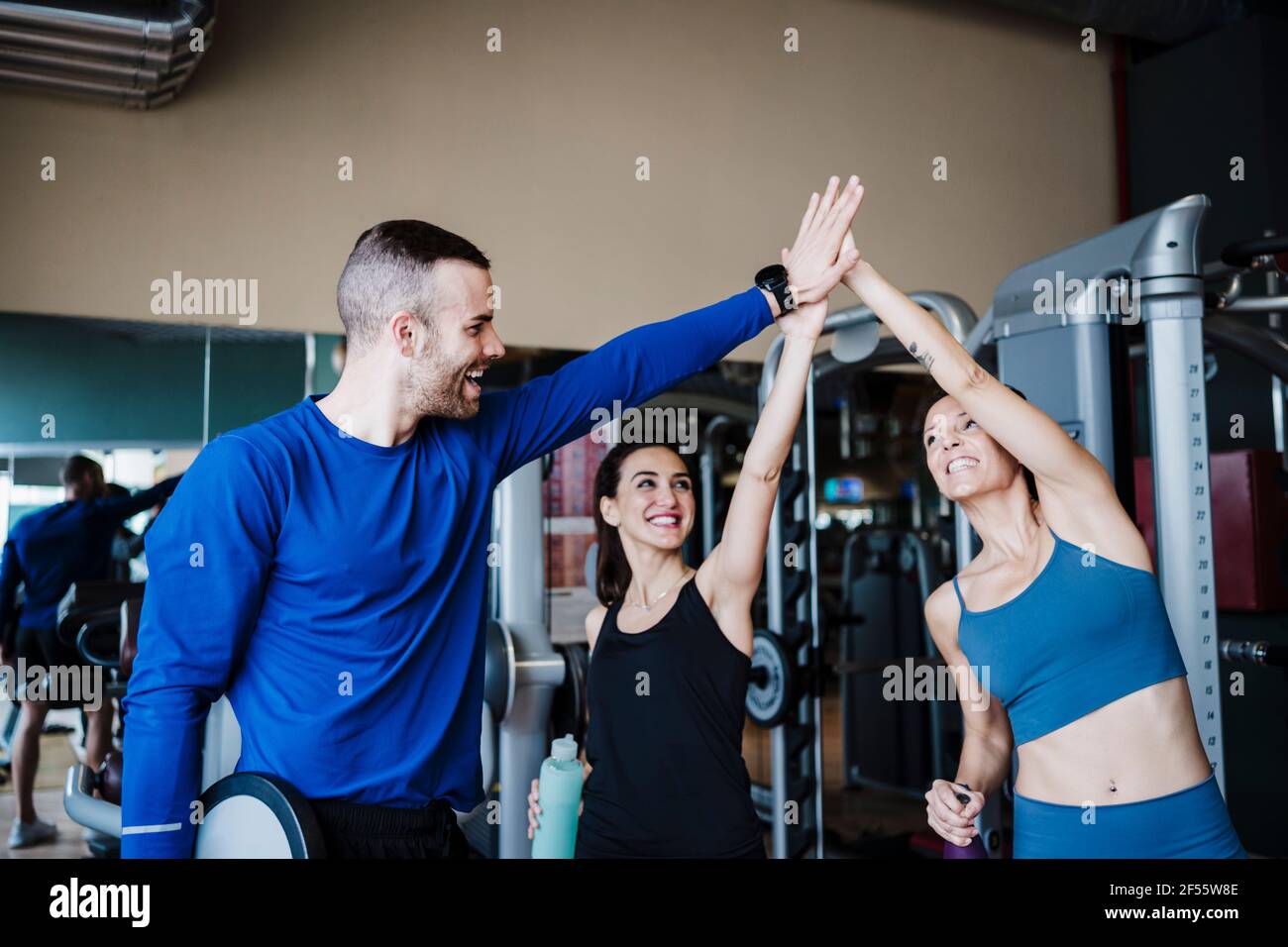 Cheerful male and female athlete giving high-five in gym Stock Photo ...
