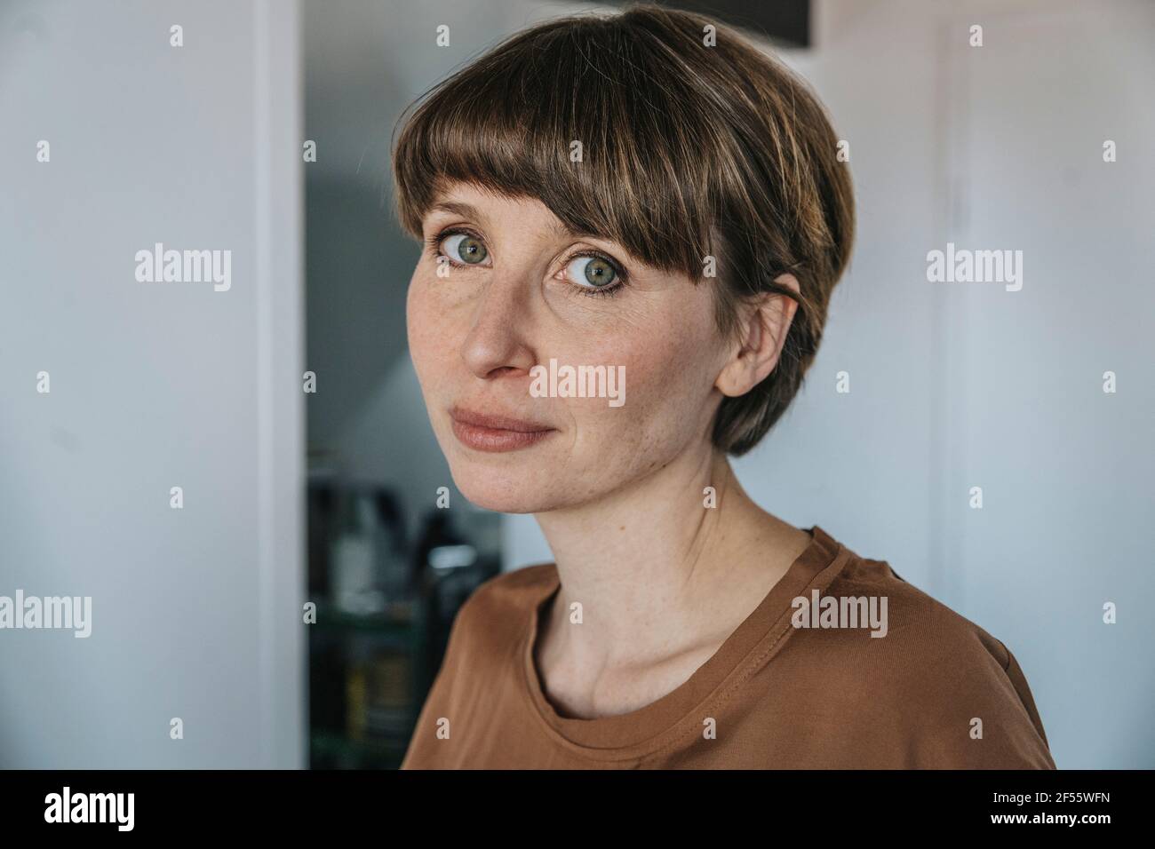 Mid adult woman with blank expression at home Stock Photo - Alamy
