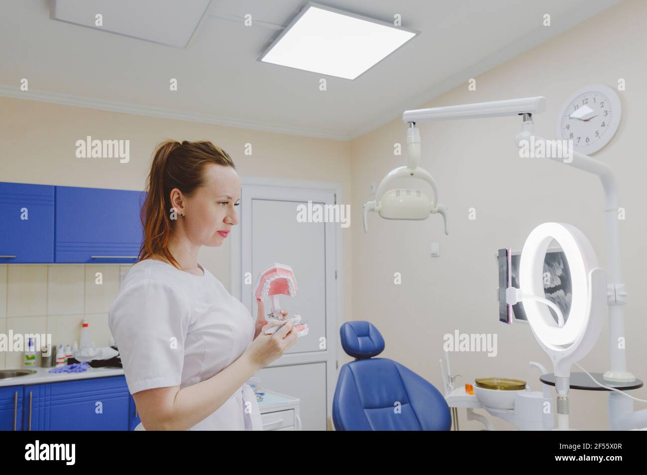 Female dentist showing dentures toward live streaming smart phone Stock ...