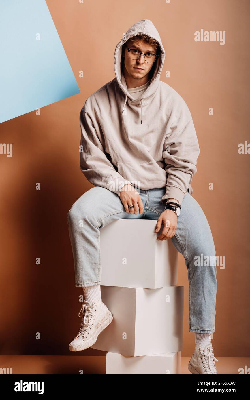 Young man sitting on box, studio hi-res stock photography and images ...