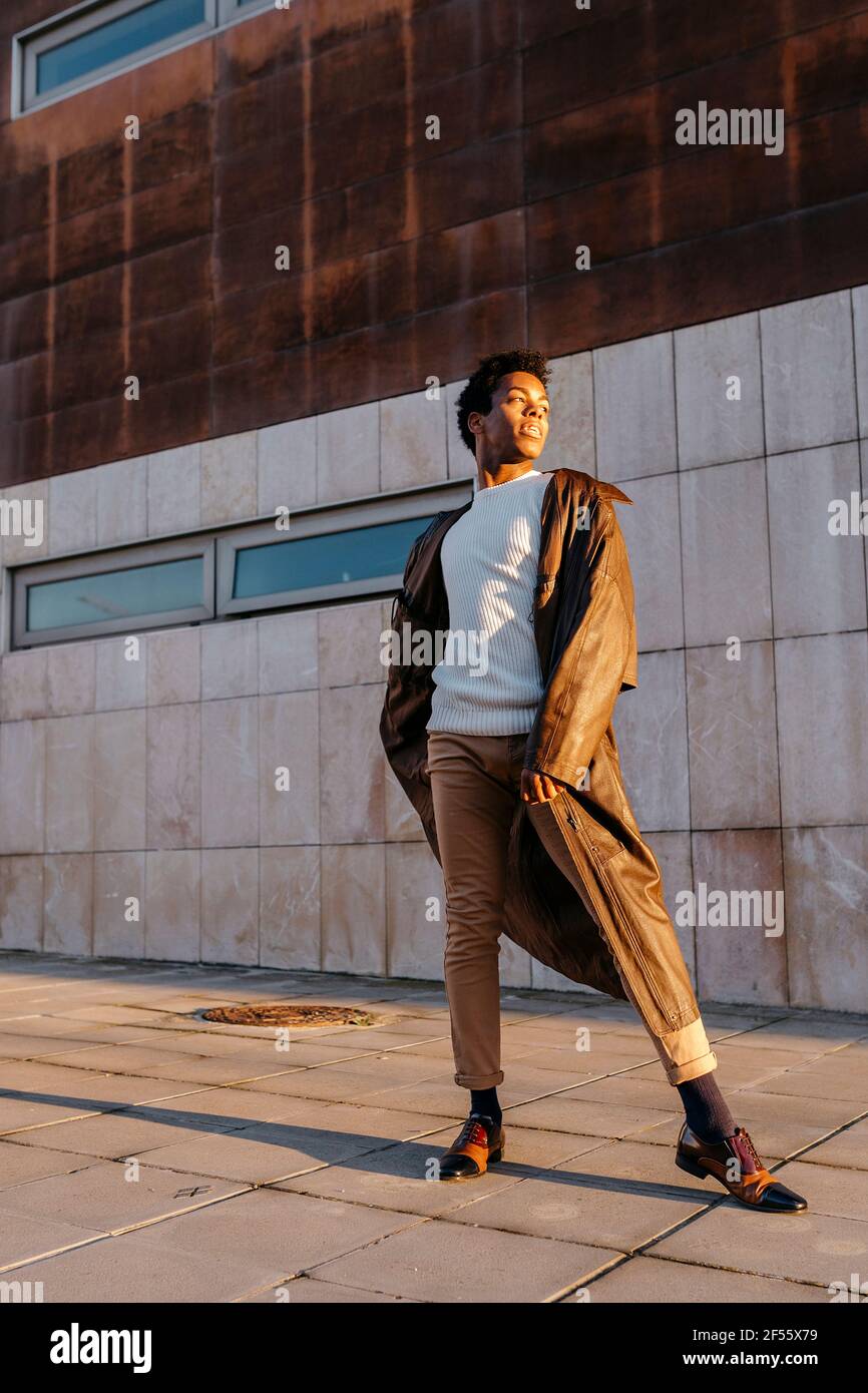 Male dancer standing against building during sunset Stock Photo - Alamy