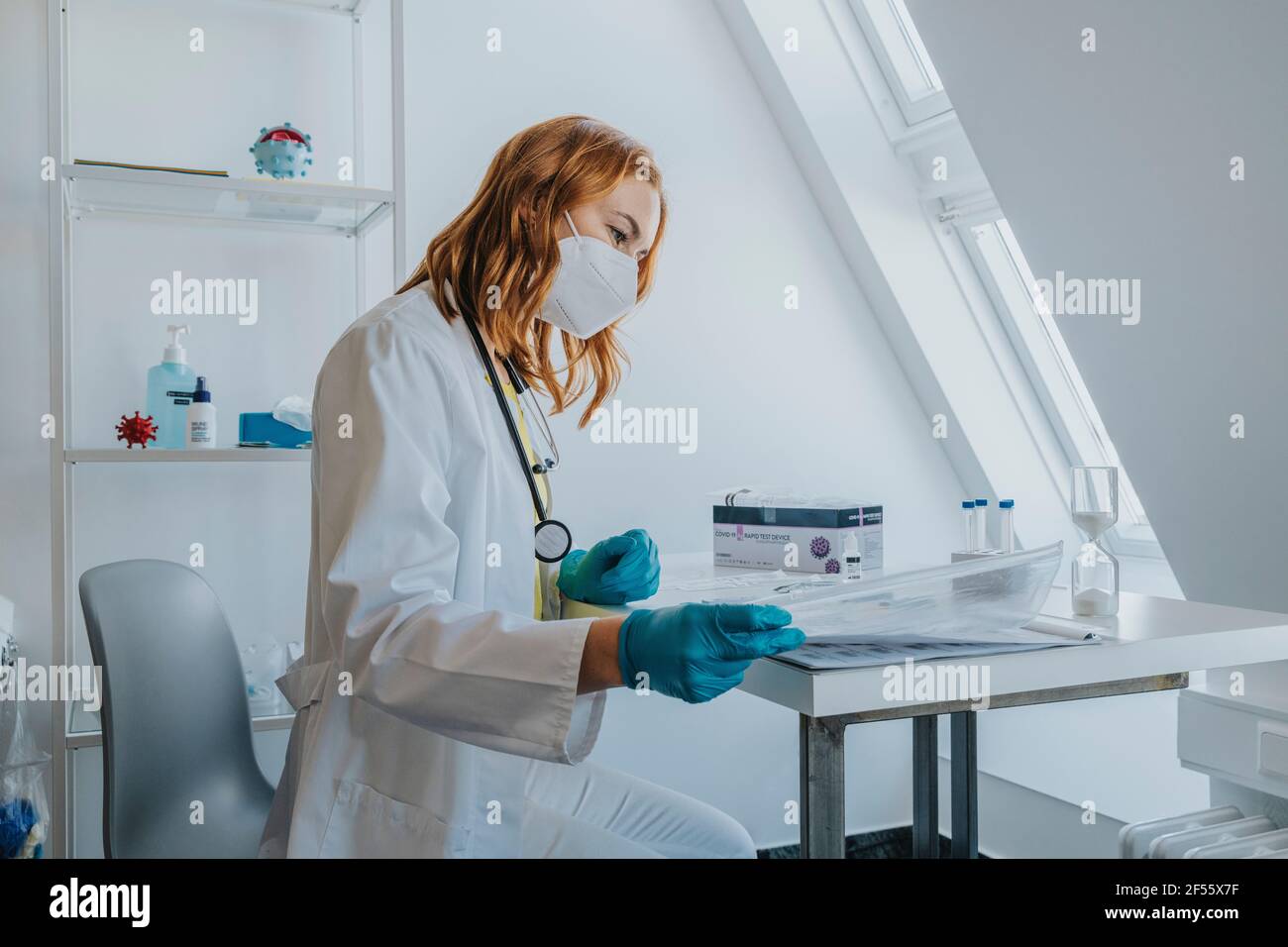 Doctor wearing protective face mask checking medical test while sitting ...