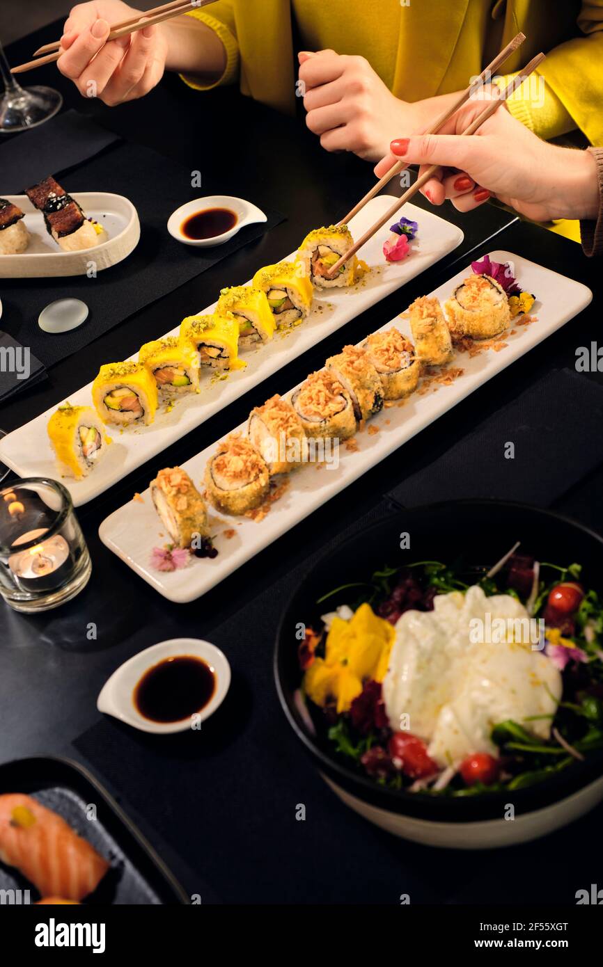 Young female friends having sushi with chopsticks at restaurant Stock ...