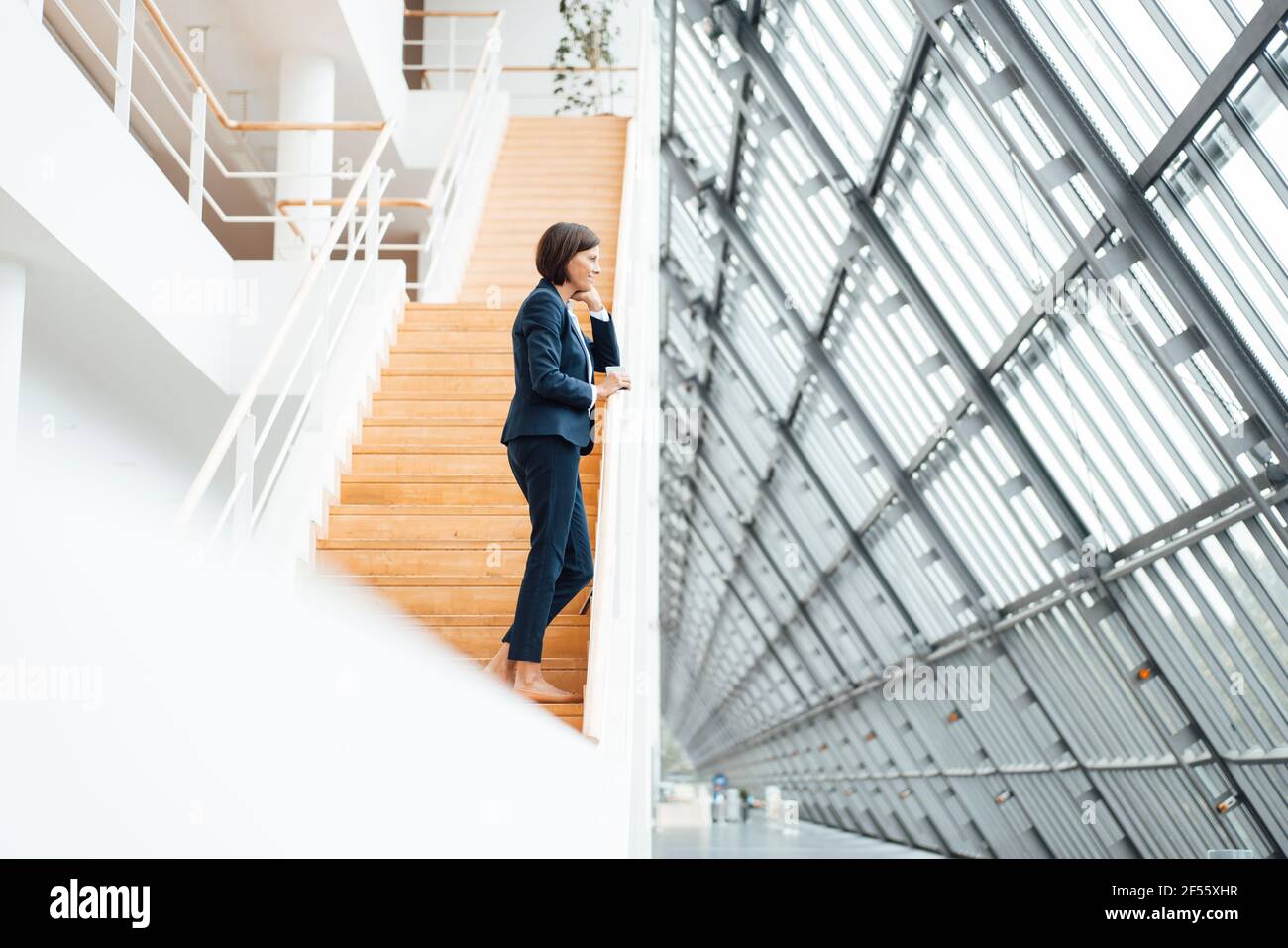 Female professional standing on steps in corridor Stock Photo - Alamy