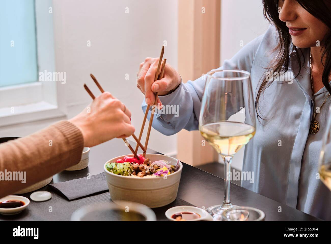Female customer having food with chopsticks at restaurant Stock Photo ...