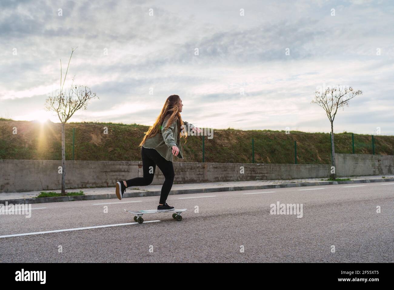 Young female skater balancing on skateboard Stock Photo - Alamy