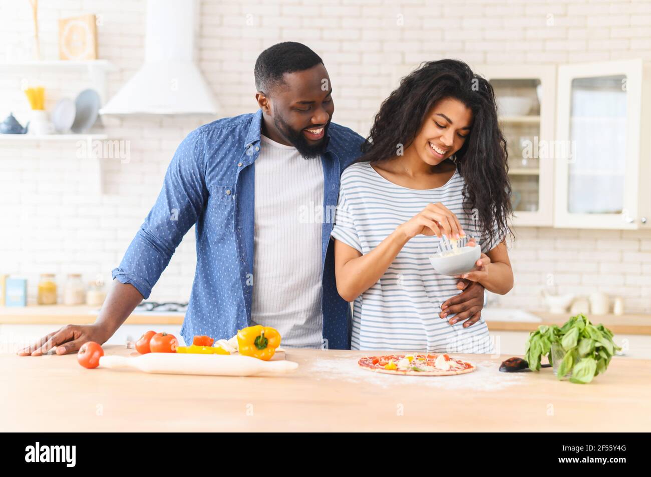 Happy african american couple cooking dinner together, trying new ...