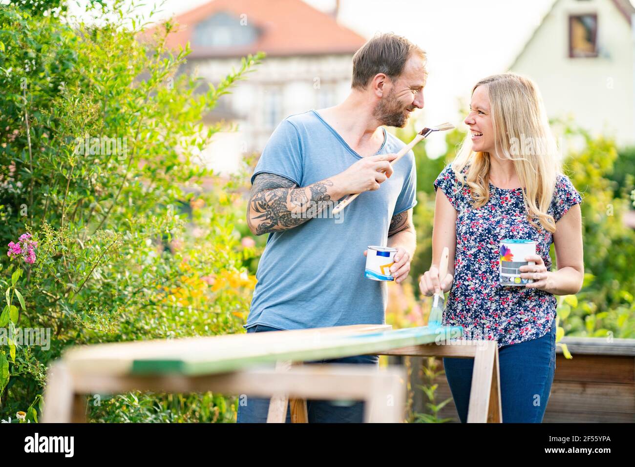 Playful man doing mischief with woman in garden Stock Photo - Alamy