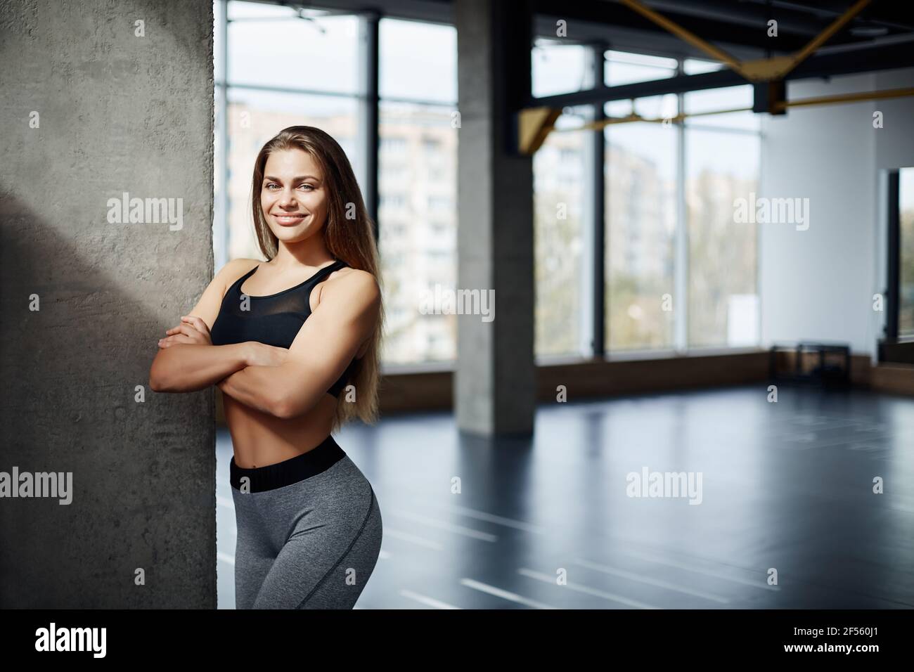 Portrait of beautiful adult fitness trainer stranding in gym. Posh ...