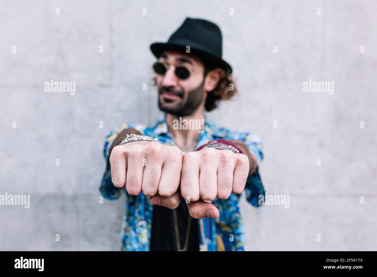 Caucasian man showing knuckles while standing in front of wall Stock ...