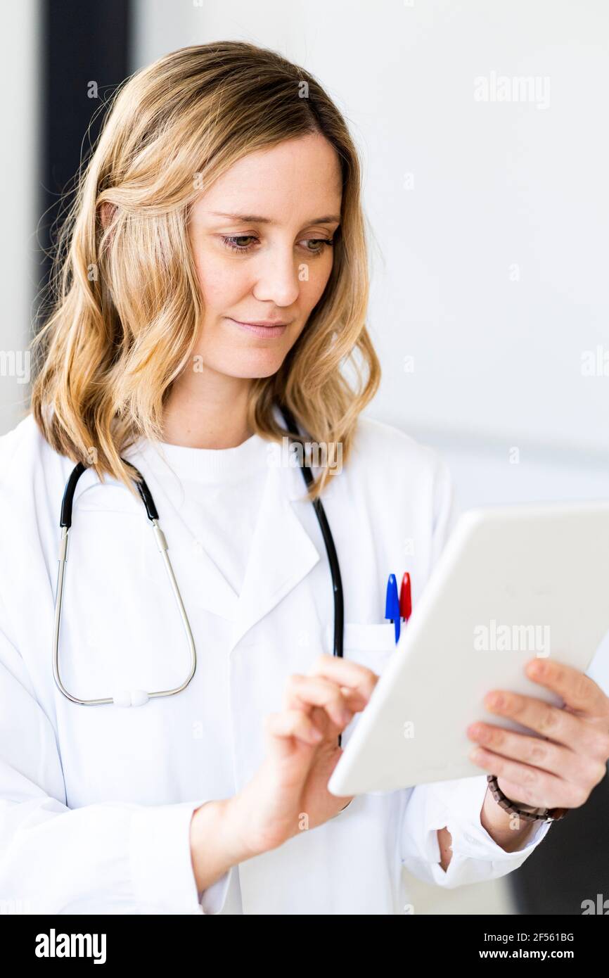Female doctor using digital tablet at medical clinic Stock Photo - Alamy