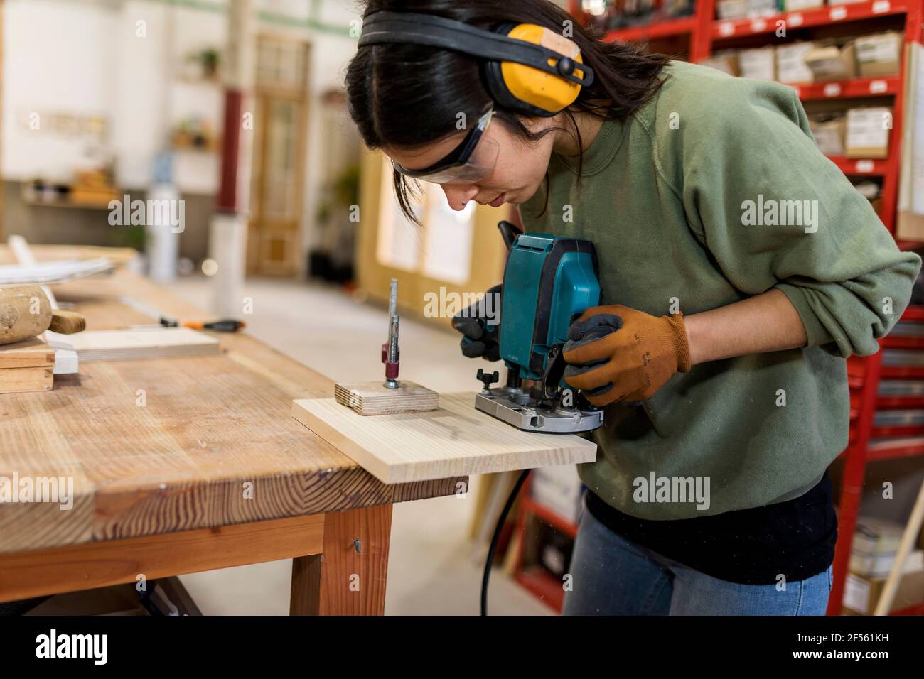 Female carpenter working with router jig at workbench in industry Stock ...