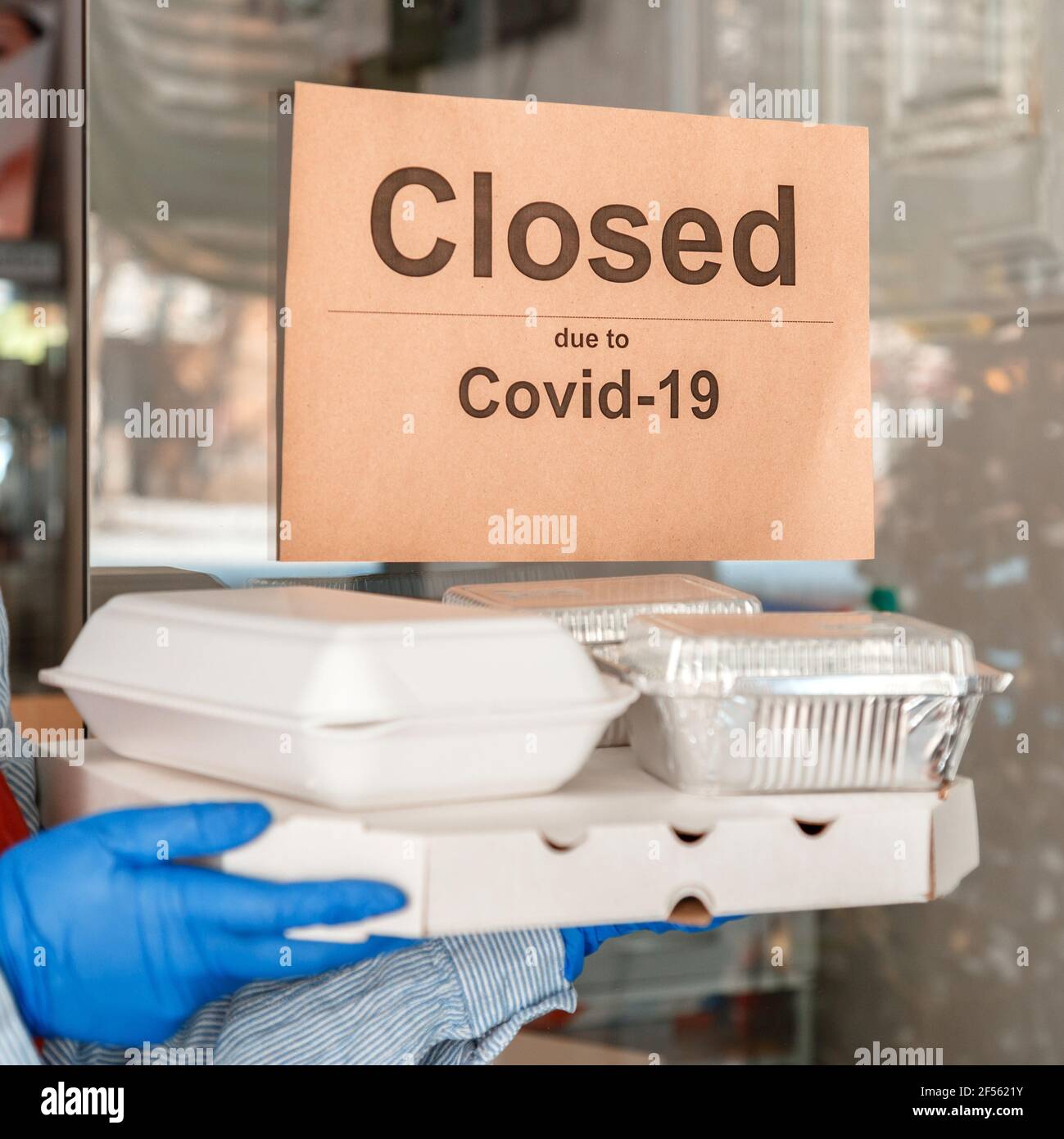 Food for delivery against sign closed due to covid 19 in Waiter hands ...