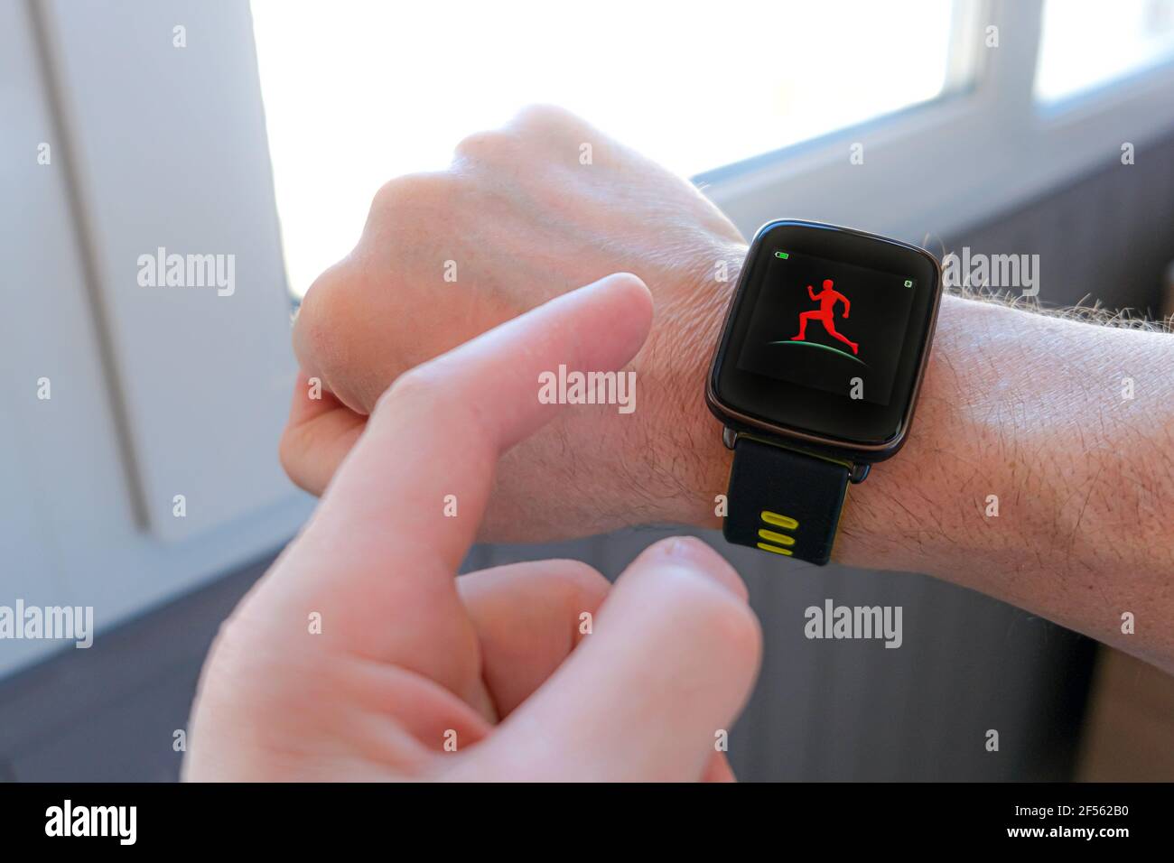 Man adjusting settings of sports watch for outdoor training Stock Photo ...