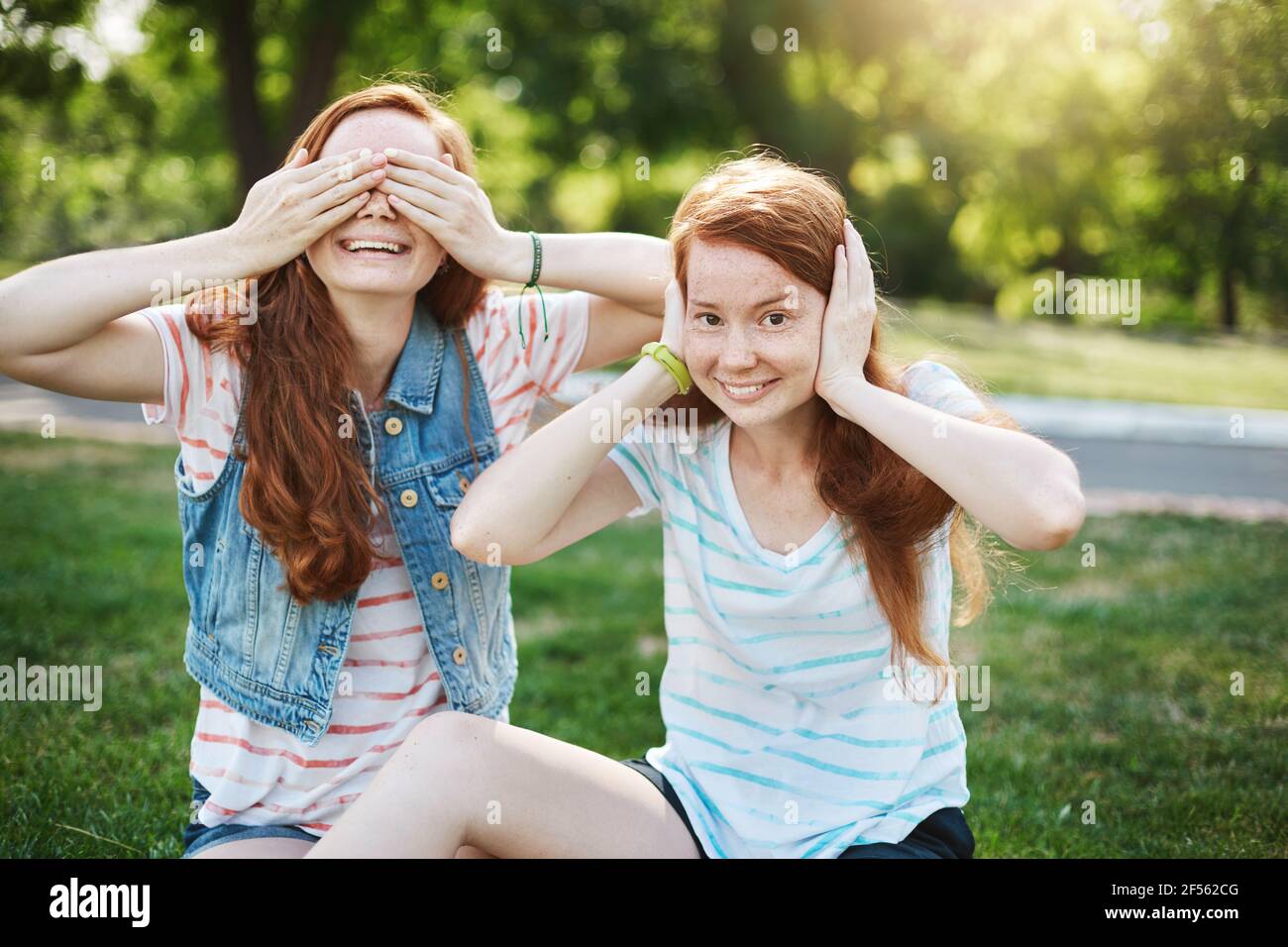 Family shot of two beautiful redhead girls with freckles fooling around ...