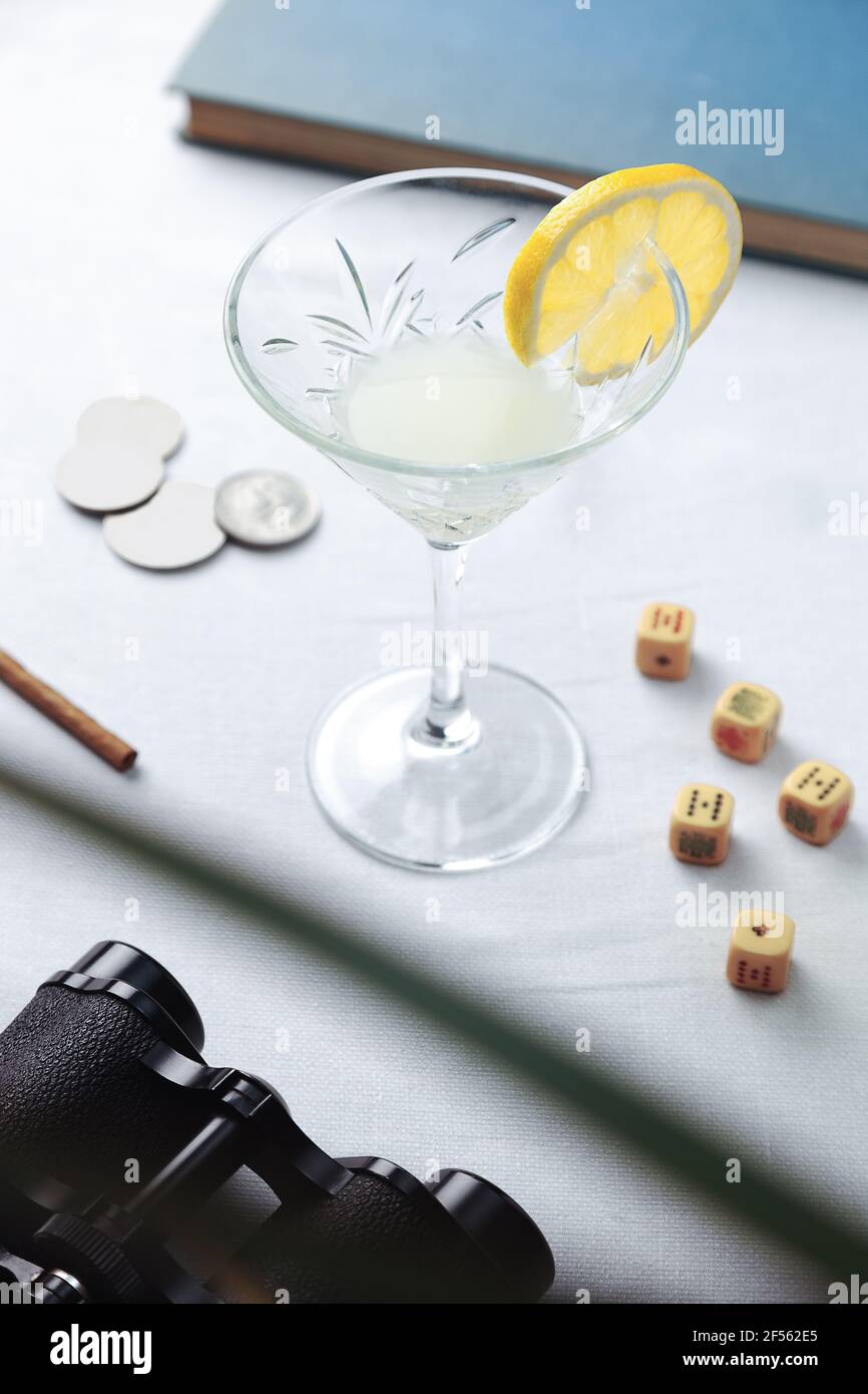 Party scene with a cocktail glass, yellow alcoholic drink and a lemon ...