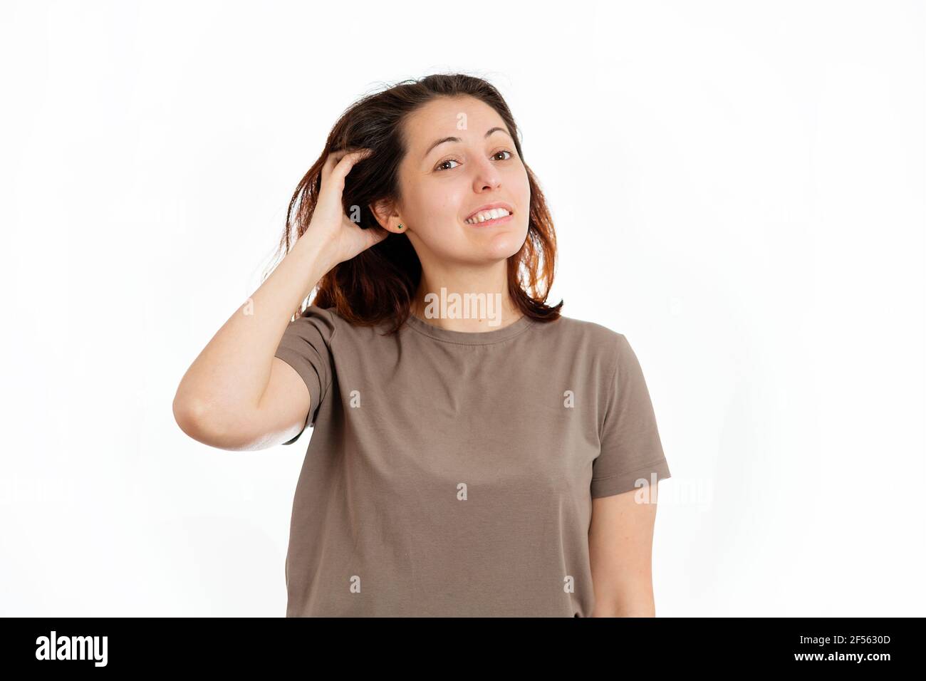 A young Caucasian woman is scratching her hair from dandruff and ...
