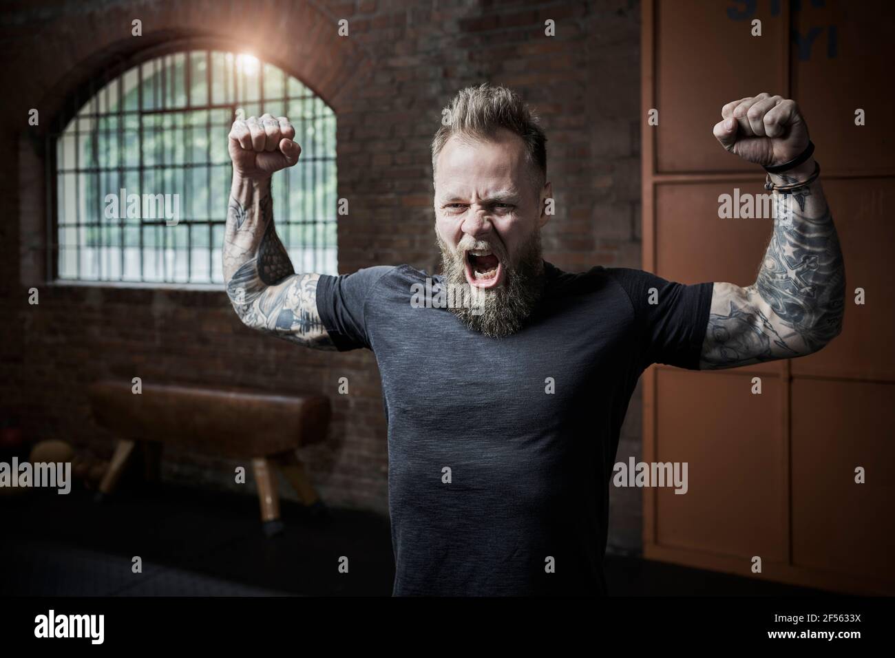 Male athlete screaming while flexing muscles in gym Stock Photo - Alamy