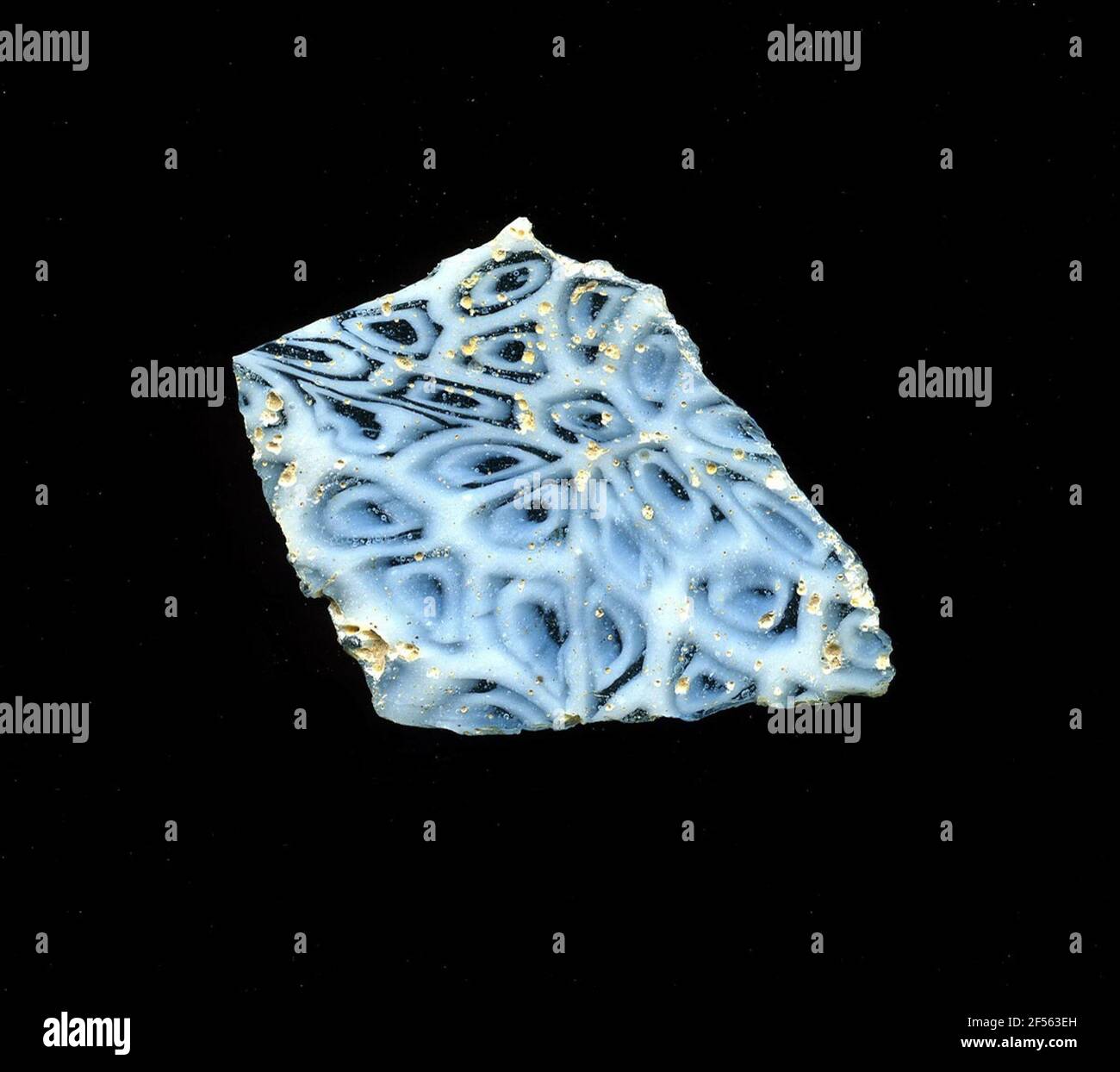 Mosaic glass fragment. The small glass fragment shows on blue ...
