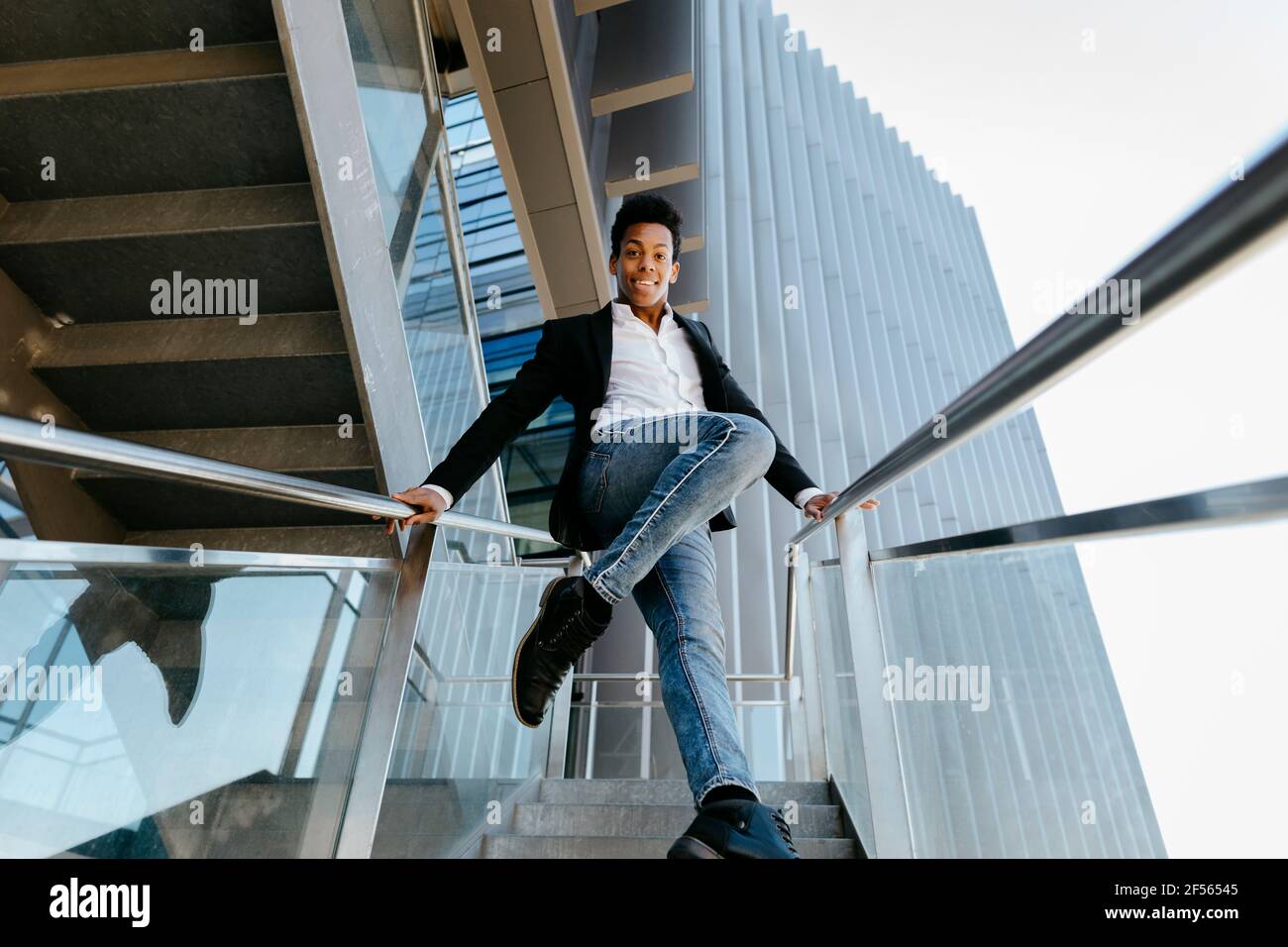 Smiling male professional dancing on staircase against building Stock ...