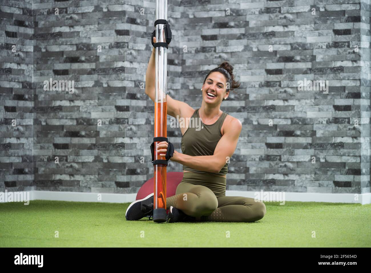 Female athlete laughing with liquid tube in gym Stock Photo - Alamy