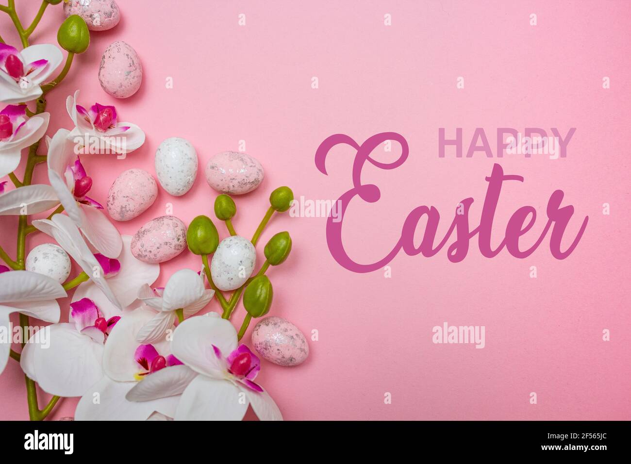 Colorful Easter eggs and flowers on pink background with happy Easter ...