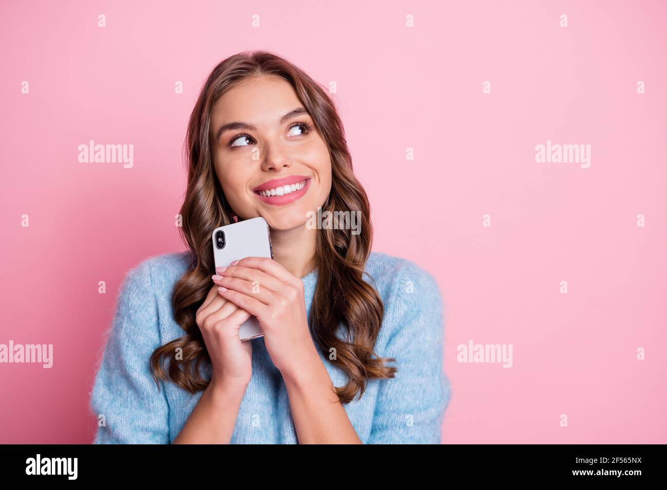 Photo Of Minded Pretty Lady Hold Telephone Look Up Empty Space Beaming