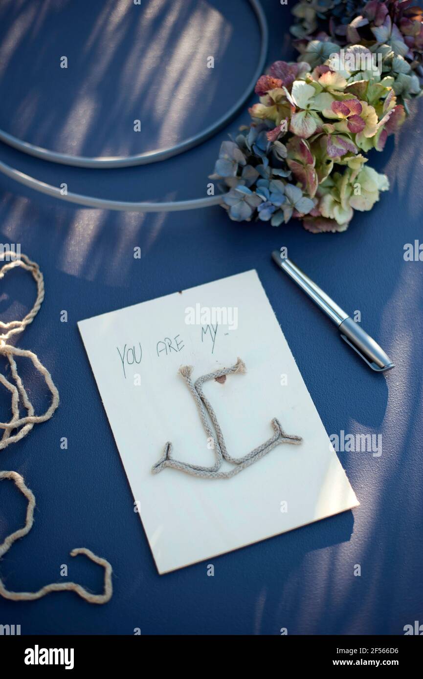 Greeting card with anchor made of piece of string Stock Photo - Alamy