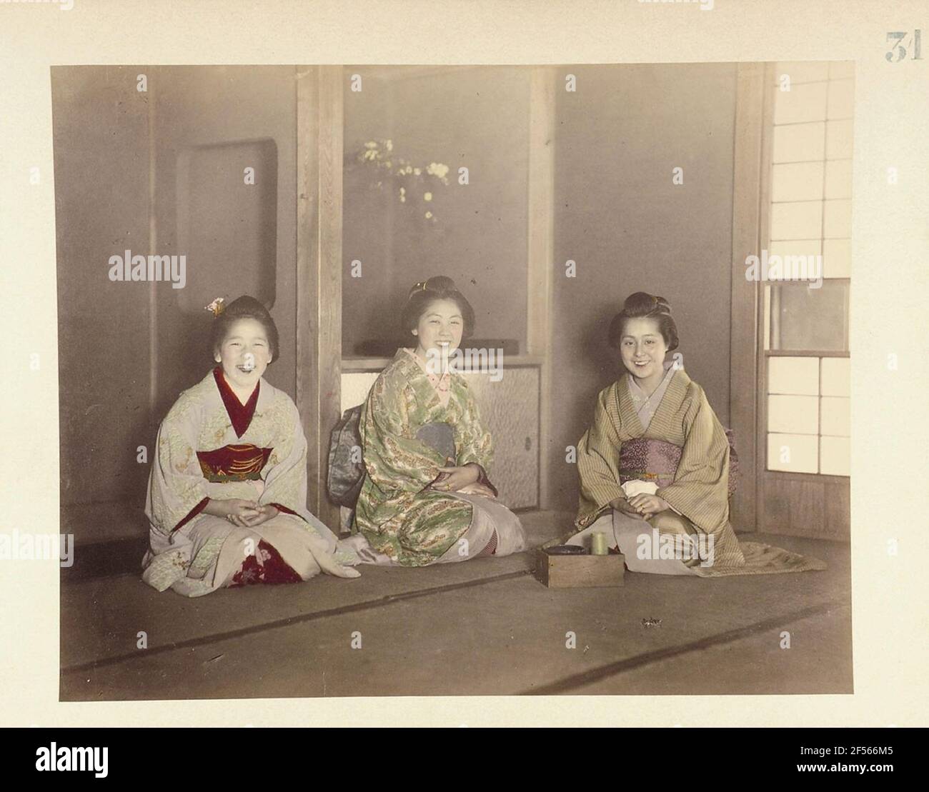 Three japanese women in the interior crouching Stock Photo - Alamy
