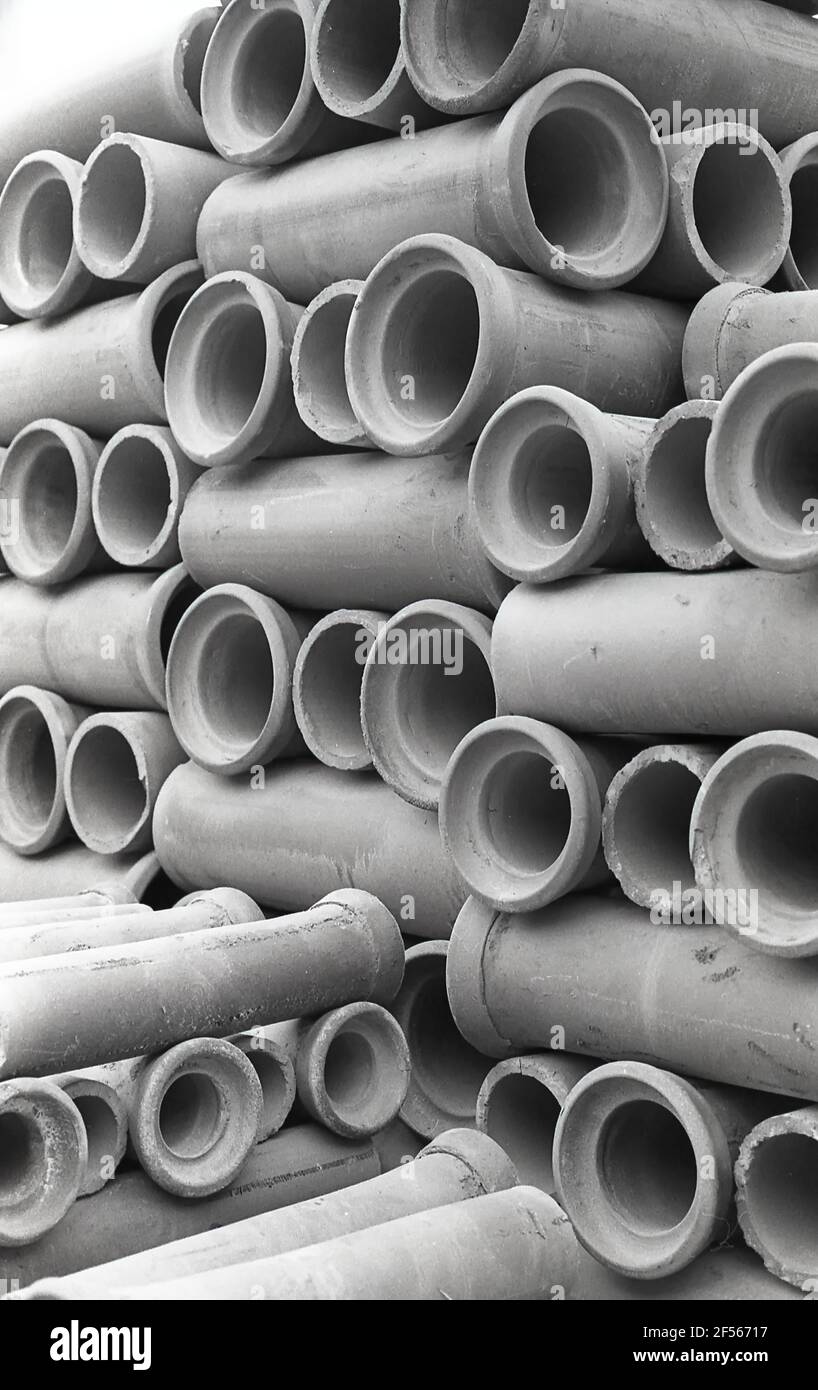 Vertical view of tall stacks of clay drainage pipes on a sunny day as ...