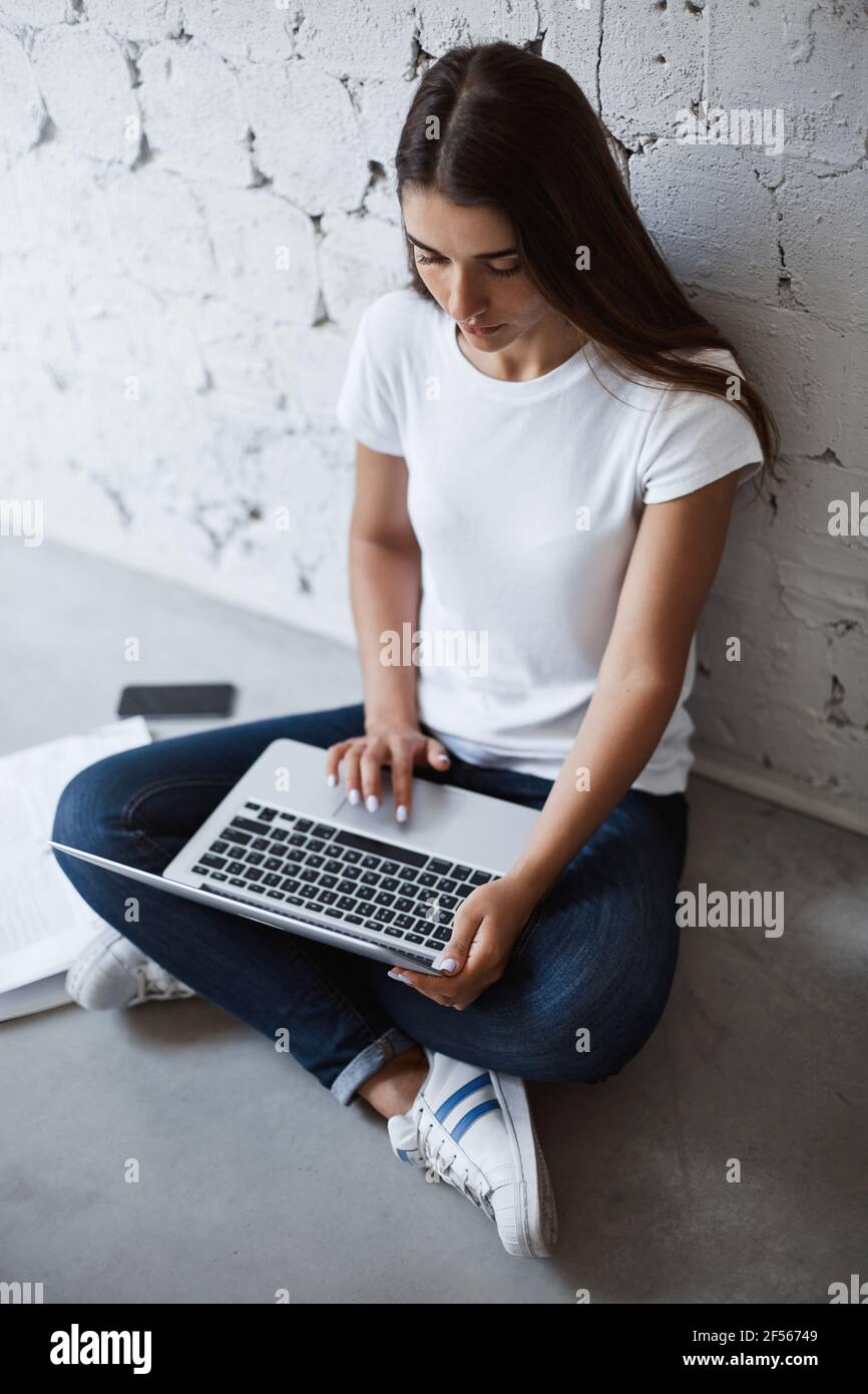 Young female architect using laptop computer to create blueprints of ...