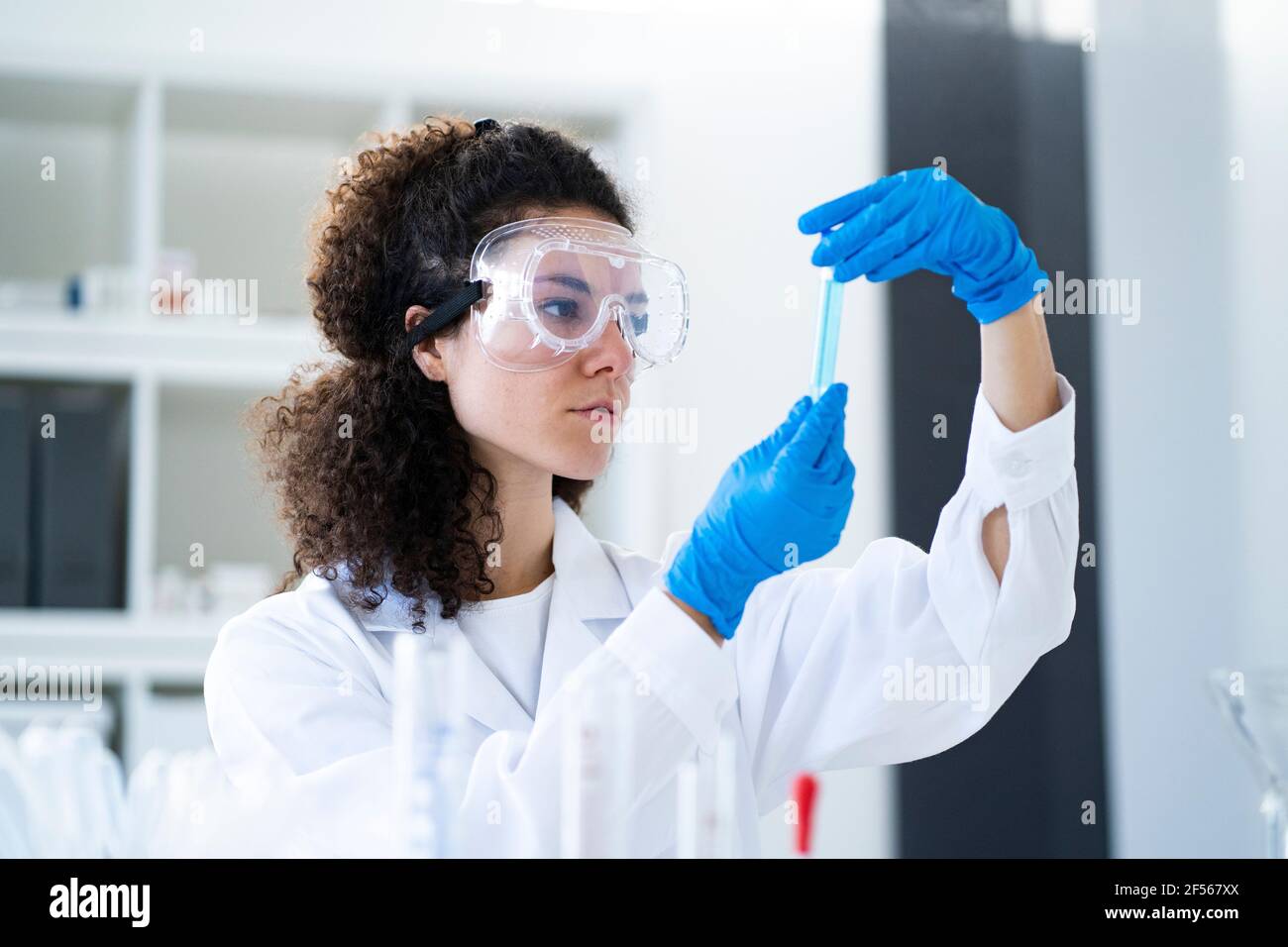 Young female scientist examining test tube at chemistry lab Stock Photo ...