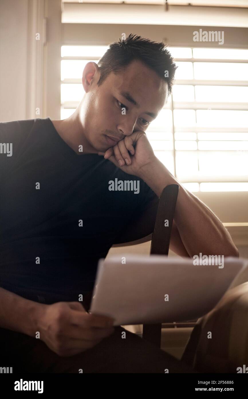 Man reading letter while sitting at home Stock Photo - Alamy