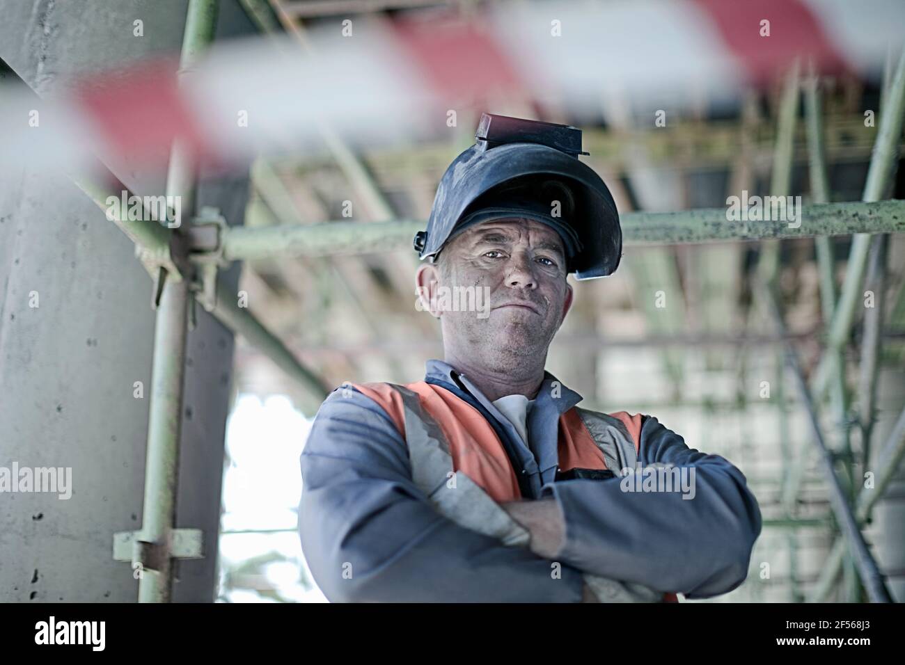 Male construction worker with arms crossed at site Stock Photo - Alamy