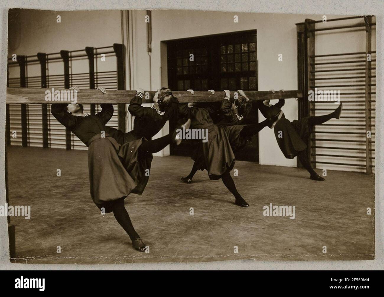 Exercises of the ladies at the beams Stock Photo - Alamy