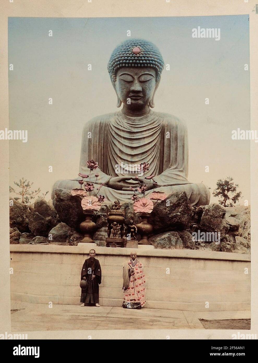 Two Japanese in front of a big cult figure, hiogo Stock Photo - Alamy