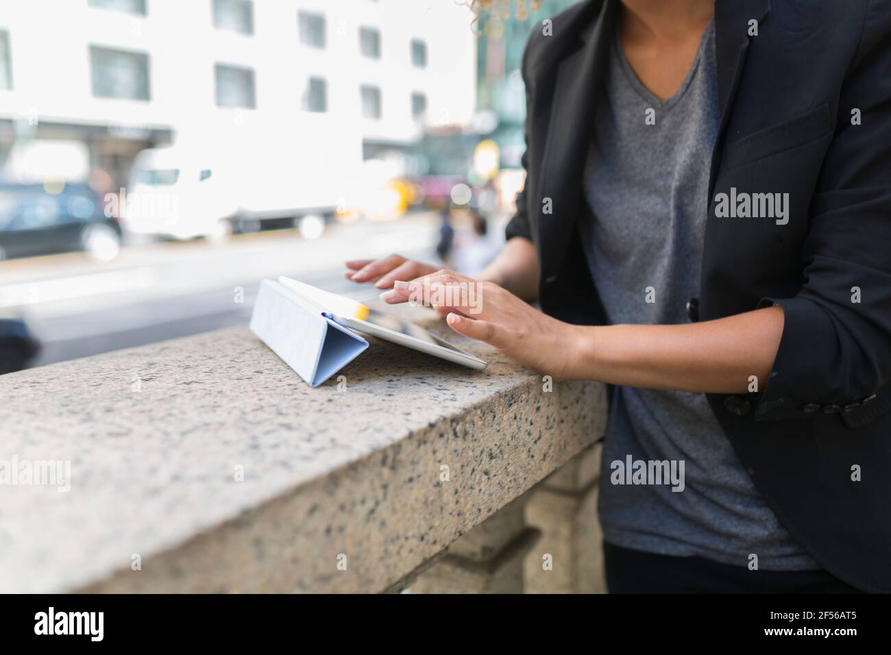 Female professional using digital tablet on retaining wall Stock Photo ...