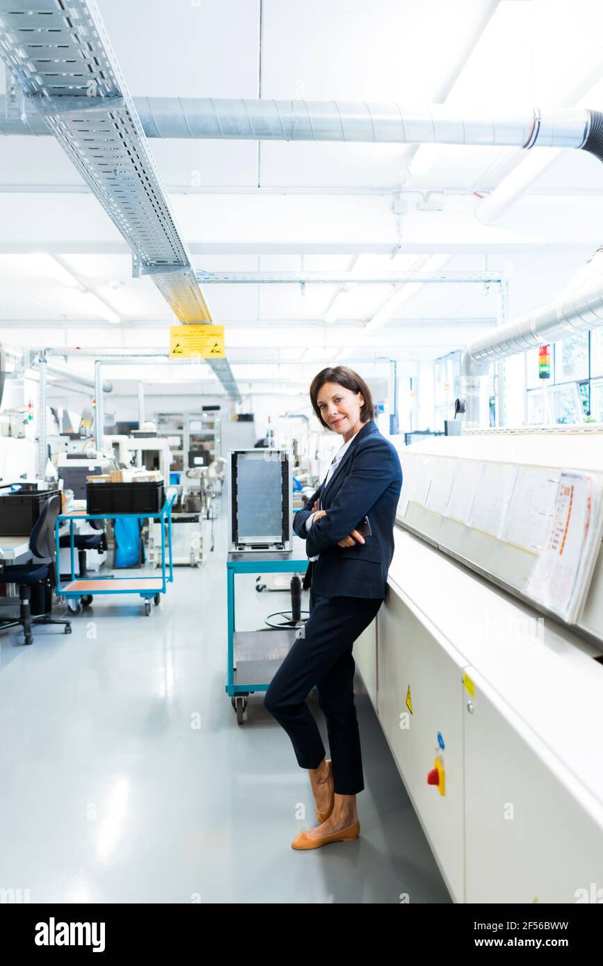 Female entrepreneur with arms crossed in factory Stock Photo - Alamy