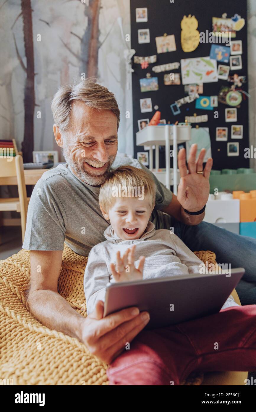 Happy father and son video calling through digital tablet Stock Photo ...