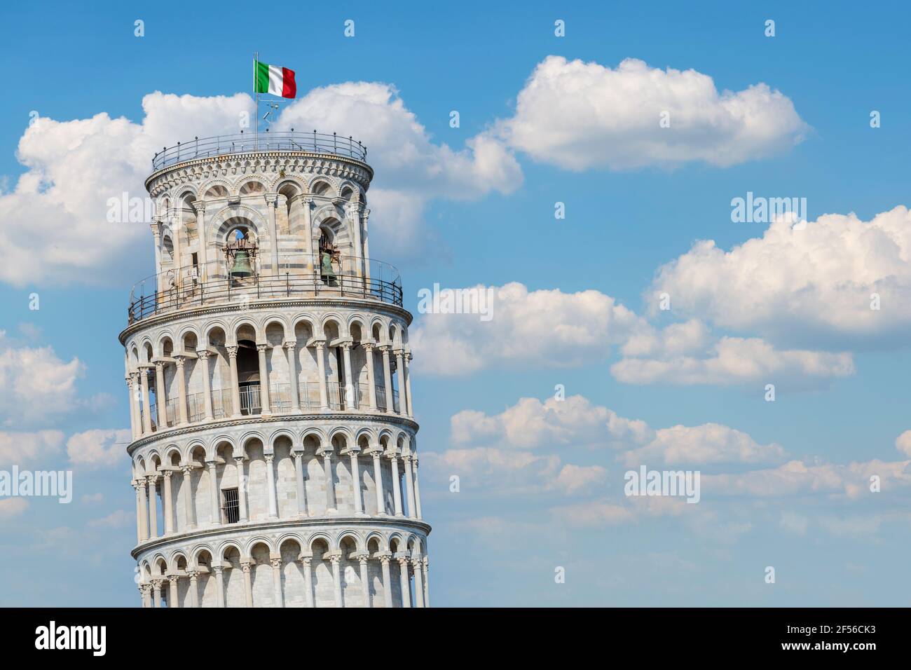 Pisa tower with italian flag in Italy. Blue sky with few clouds in the ...
