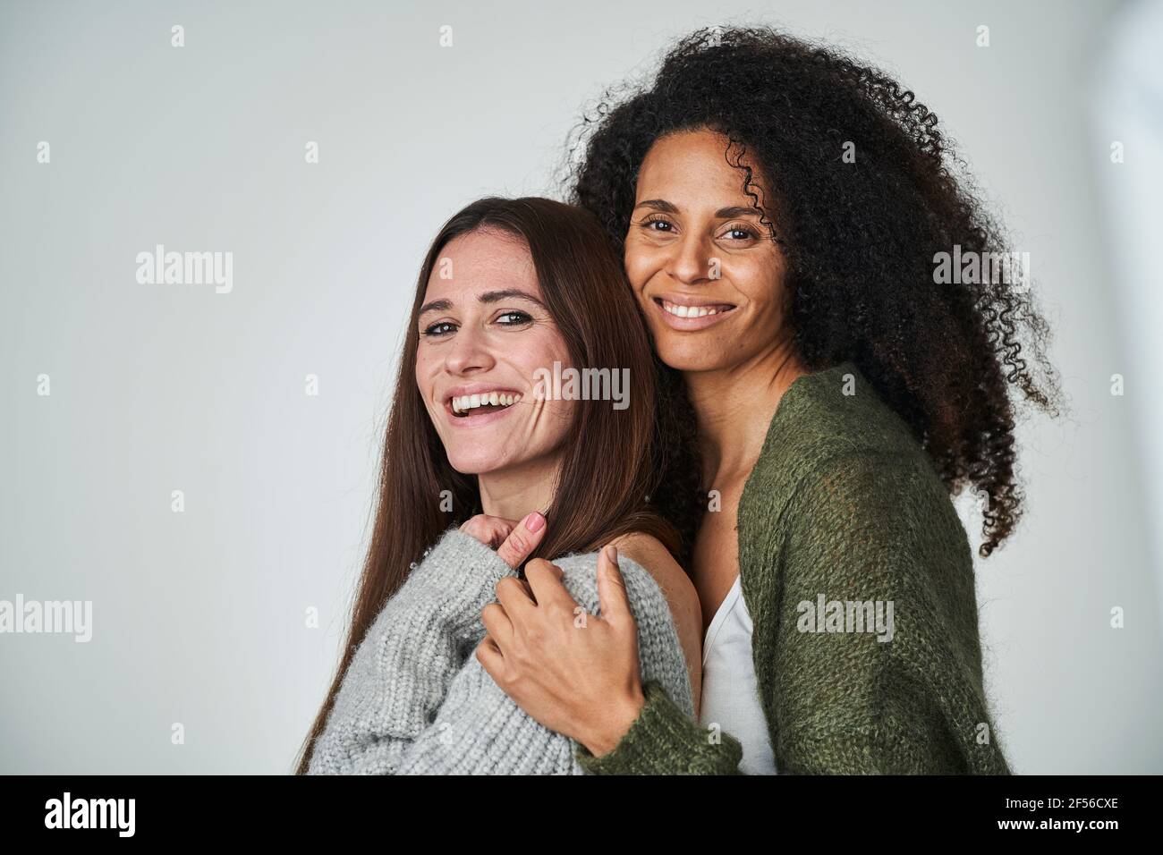Happy female friends on gray background Stock Photo - Alamy