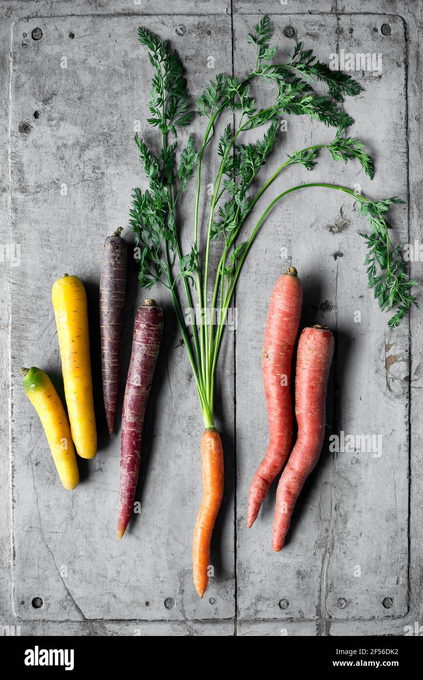 Carrots lying on gray wooden surface Stock Photo - Alamy