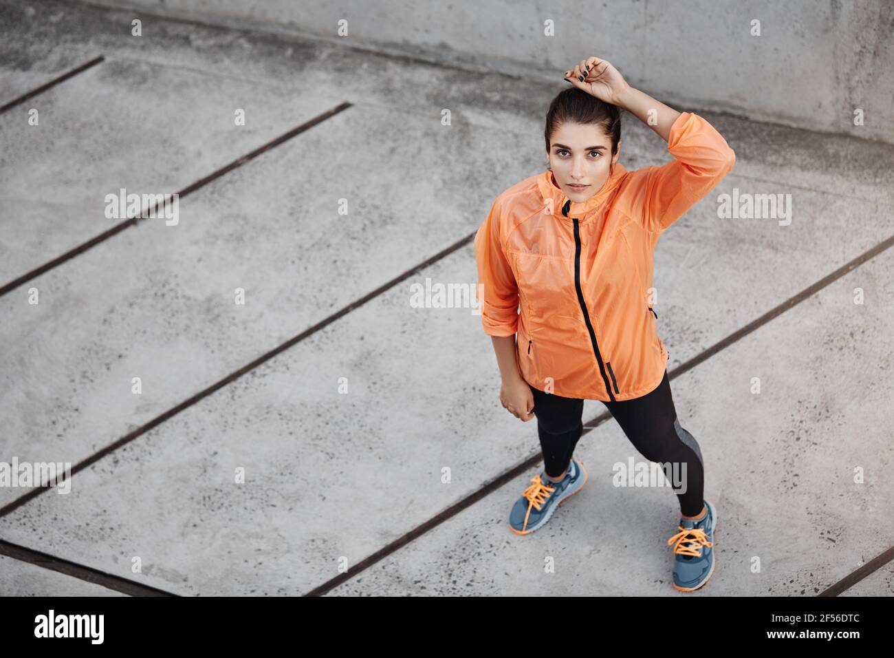 Upper view motivated confident young brunette woman in orange running ...