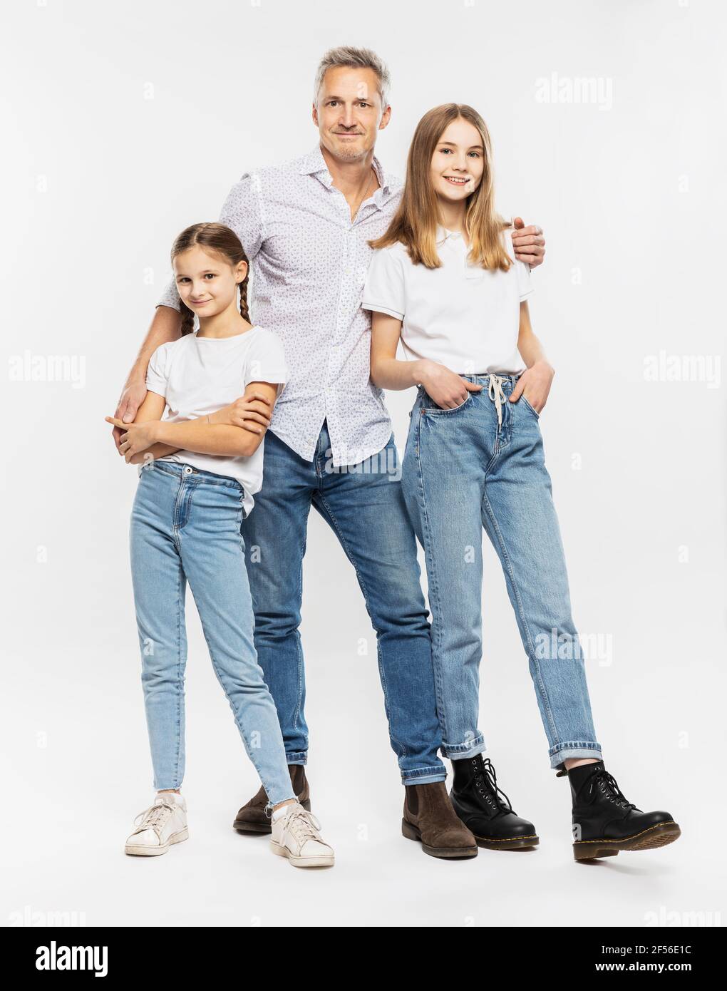 Father and daughters standing together against white background Stock ...