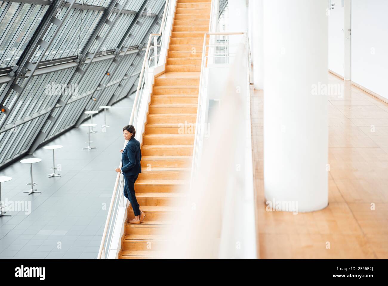 Female professional standing on steps in corridor Stock Photo - Alamy