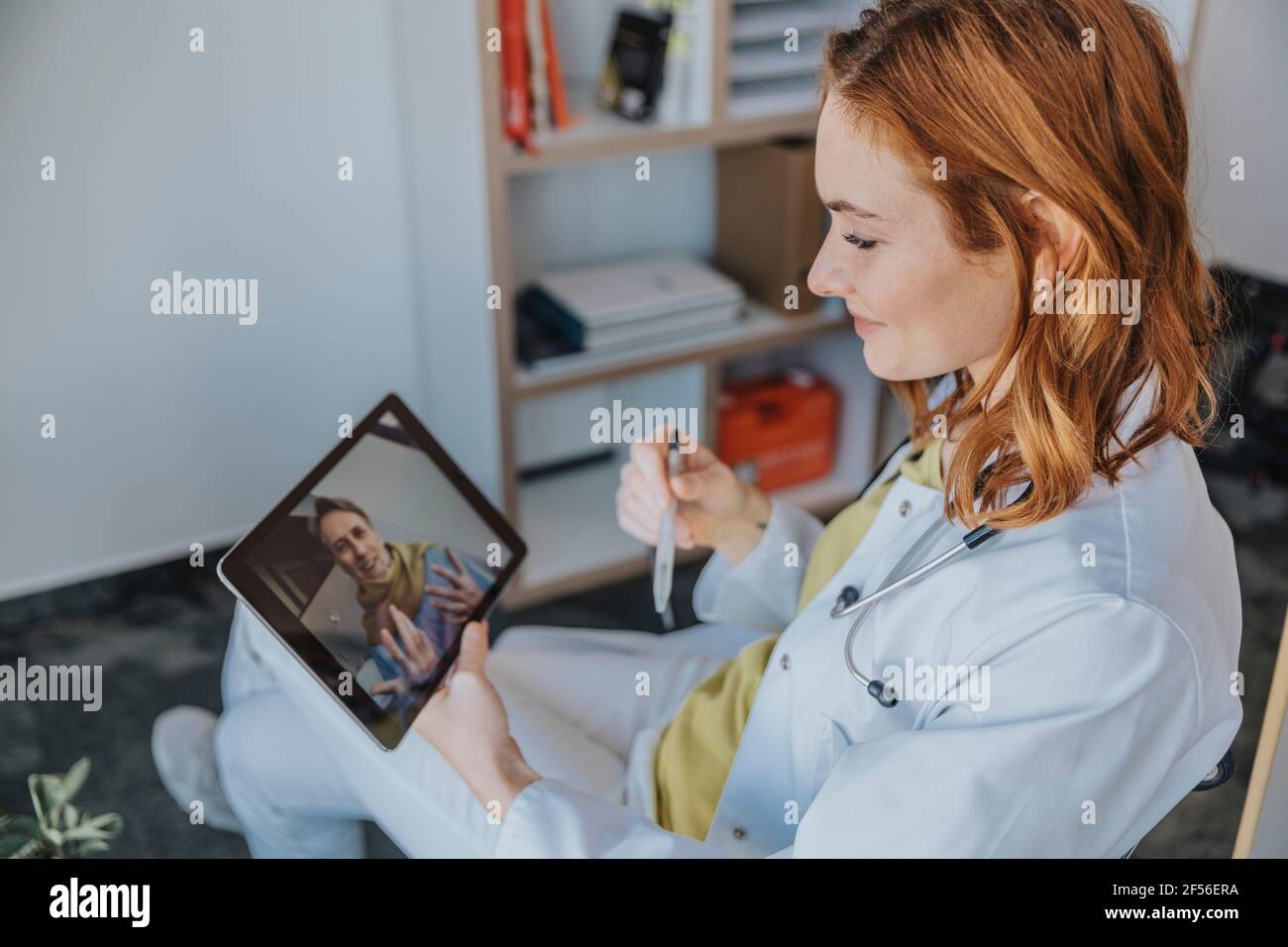 General practitioner talking with patient through video call over ...