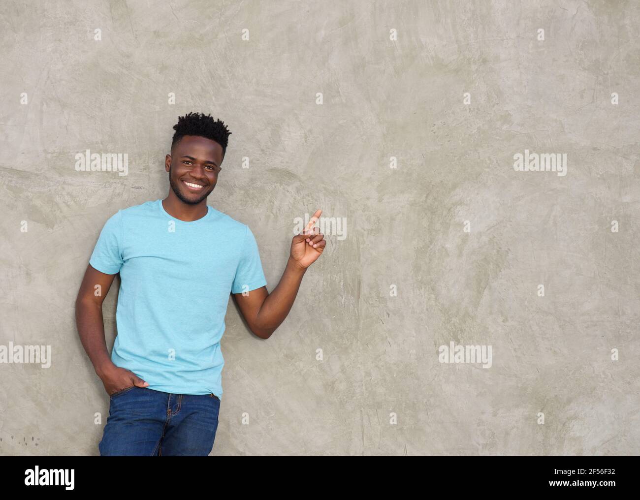 Portrait of confident young man pointing and smiling Stock Photo - Alamy