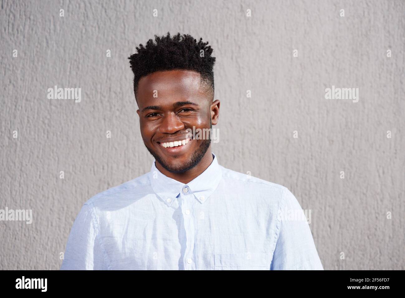 Close up portrait of attractive African man smiling and standing by ...